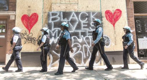 left chicago police walk by a boarded up business while following a ...