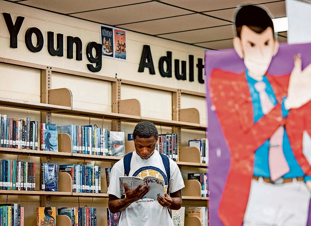 FILE/GAVIN MCINTYRE/STAFF Malaki Graham reads a book in the young adult ...