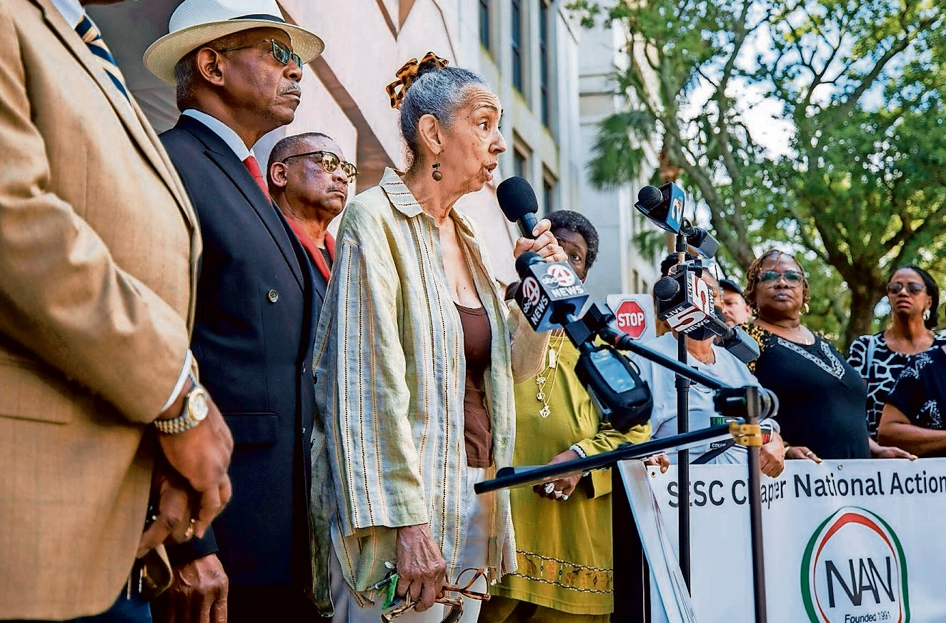 dr millicent brown stands with community leaders while addressing ...